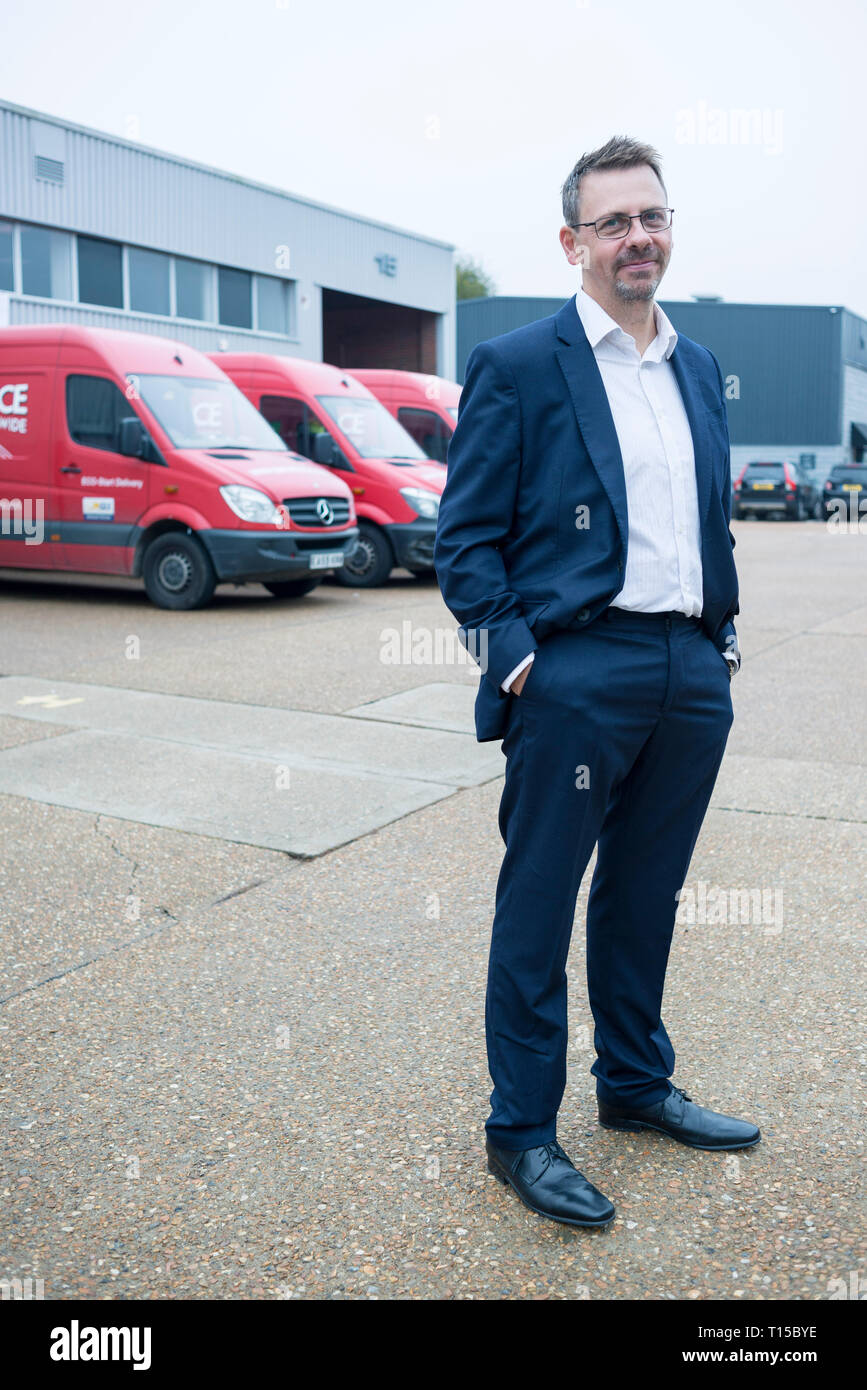 A businessman standing while wearing a suit and looking smart in a ...