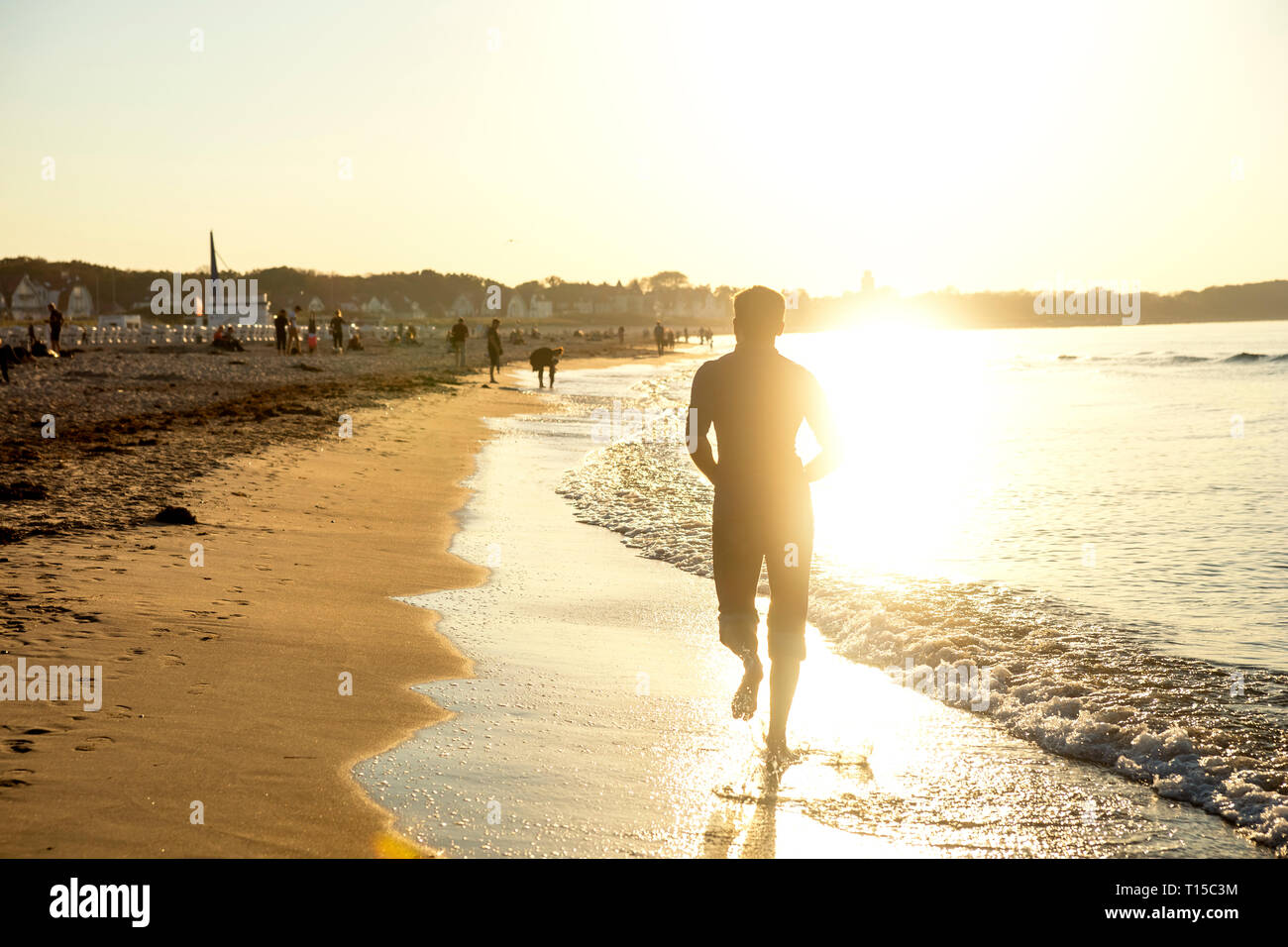 Man jogging at the beach at sunset Stock Photo - Alamy