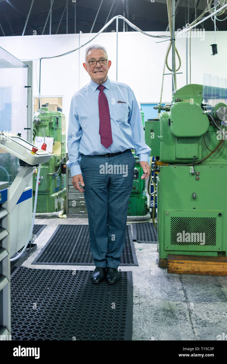 A friendly older gentleman / business owner standing in and on the ...