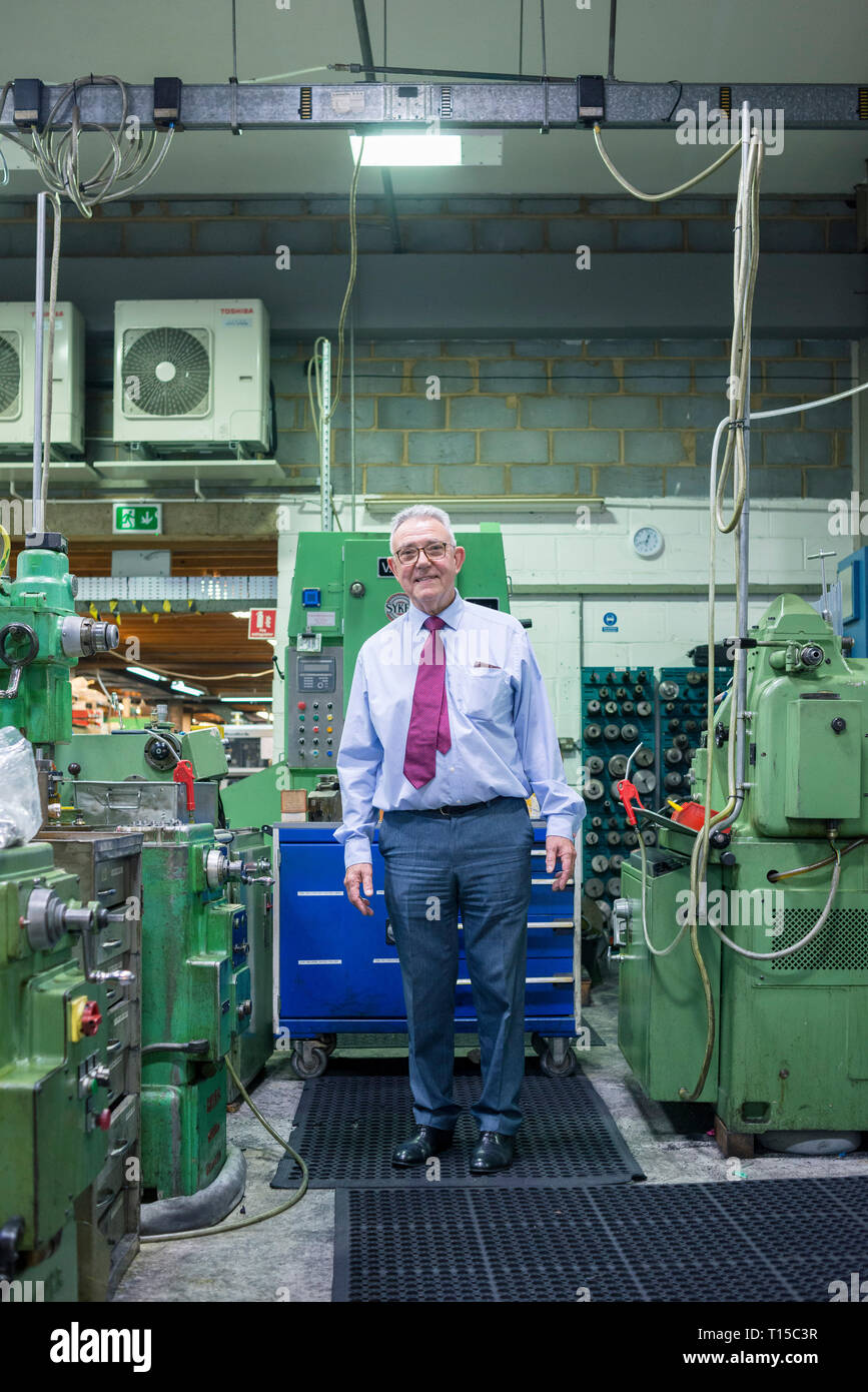 A friendly older gentleman / business owner standing in and on the ...