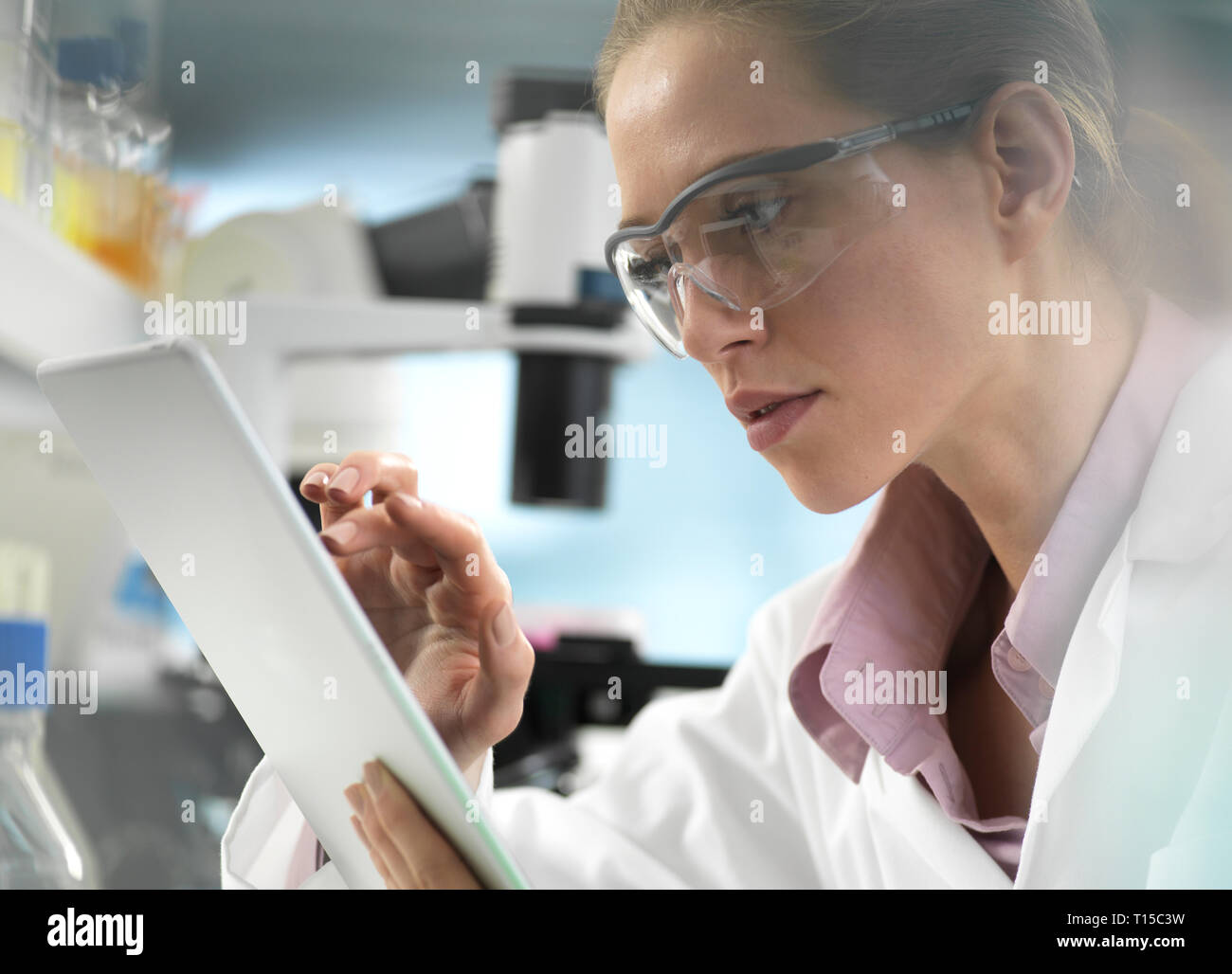 Scientist adding data to a tablet during an experiment in the ...