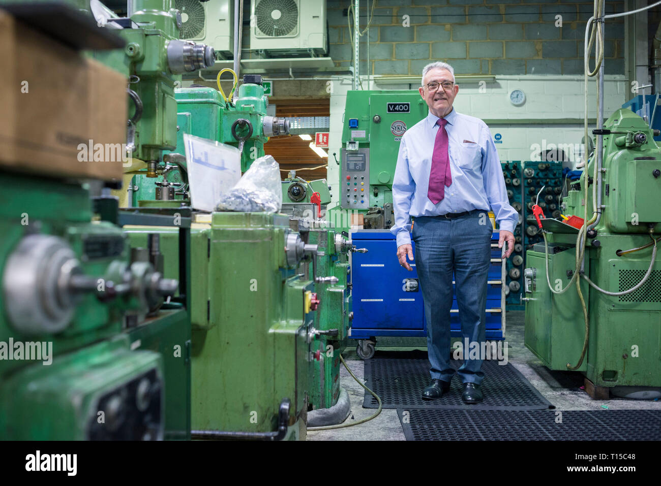 A friendly older gentleman / business owner standing in and on the ...