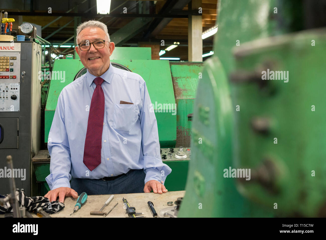 A friendly older gentleman / business owner standing in and on the ...