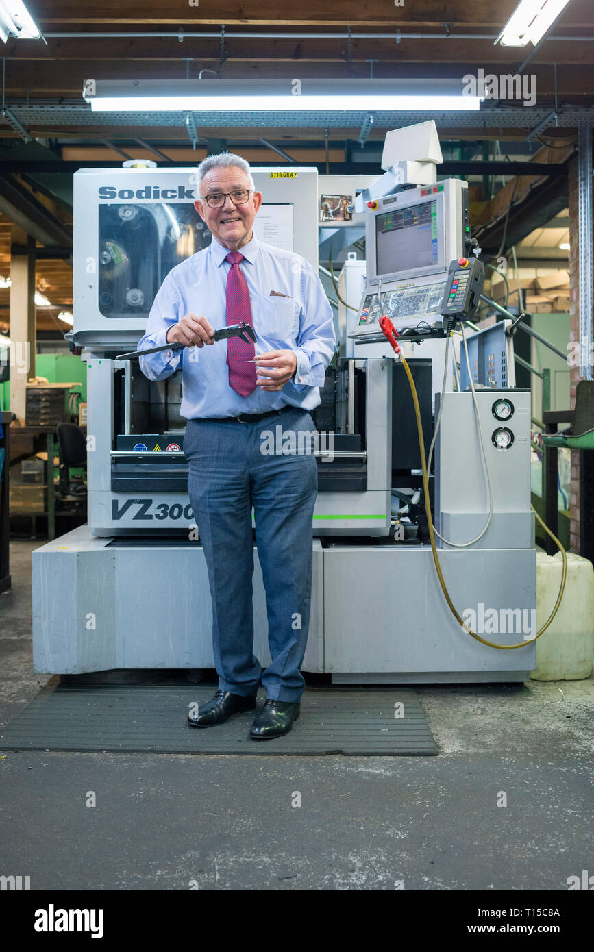 A friendly older gentleman / business owner standing in and on the ...