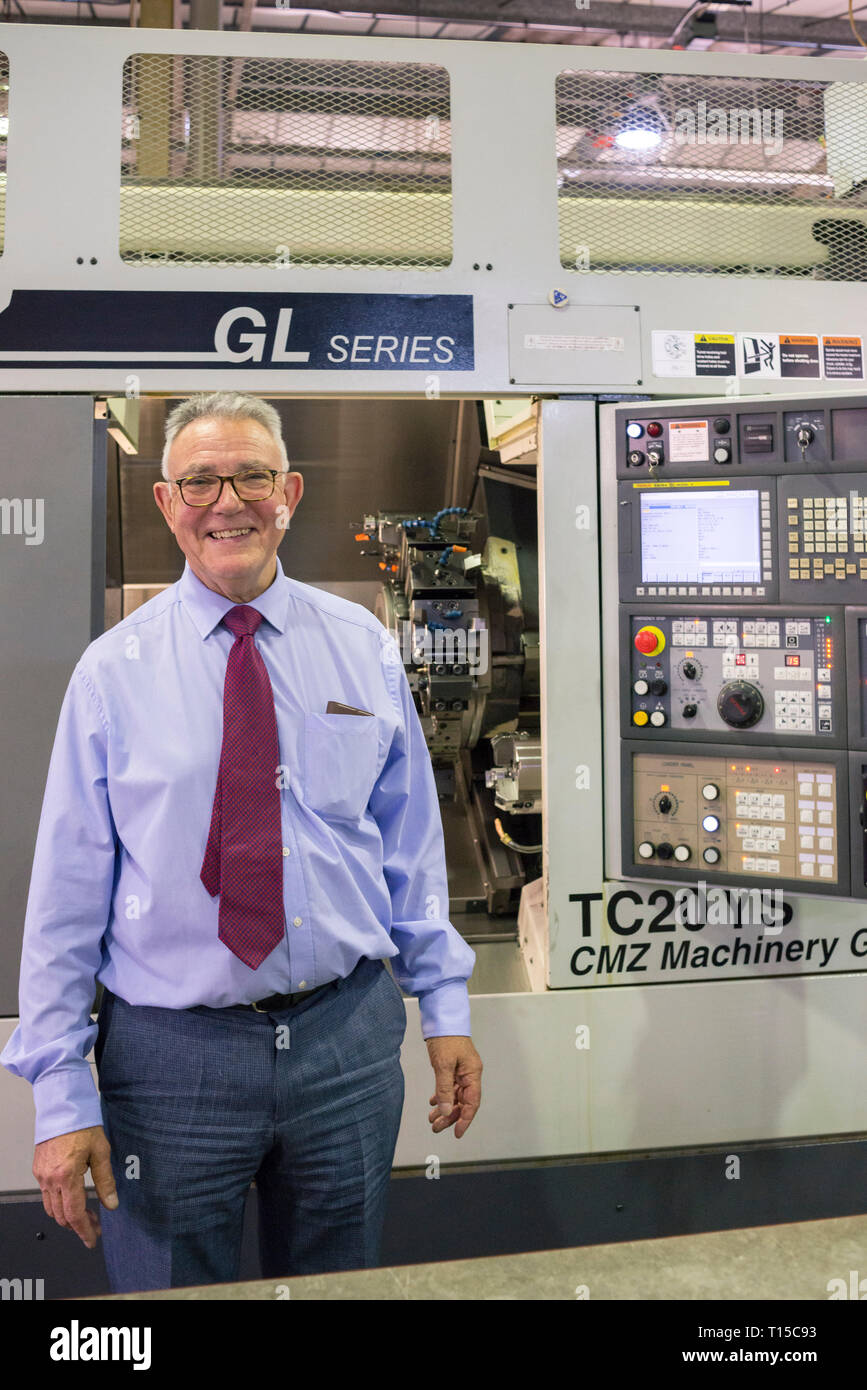 A friendly older gentleman / business owner standing in and on the ...