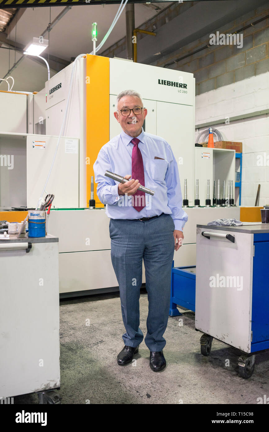 A friendly older gentleman / business owner standing in and on the ...