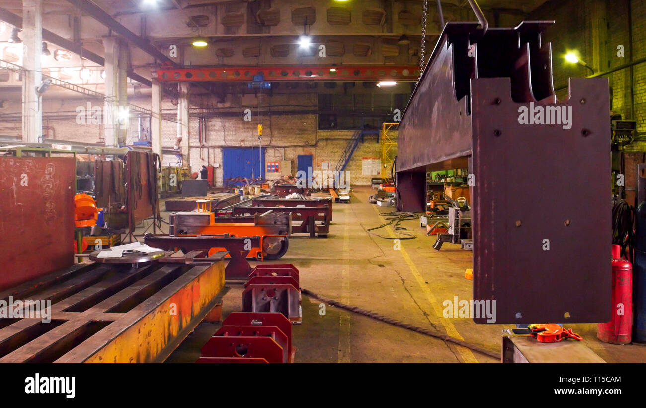 A construction plant. A crane lifting on a big iron detail and moves it ...