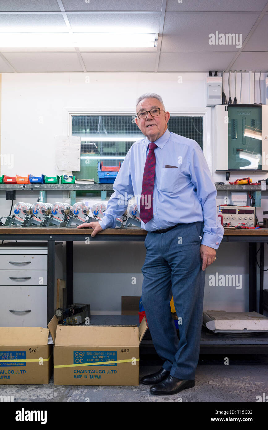 A friendly older gentleman / business owner standing in and on the ...