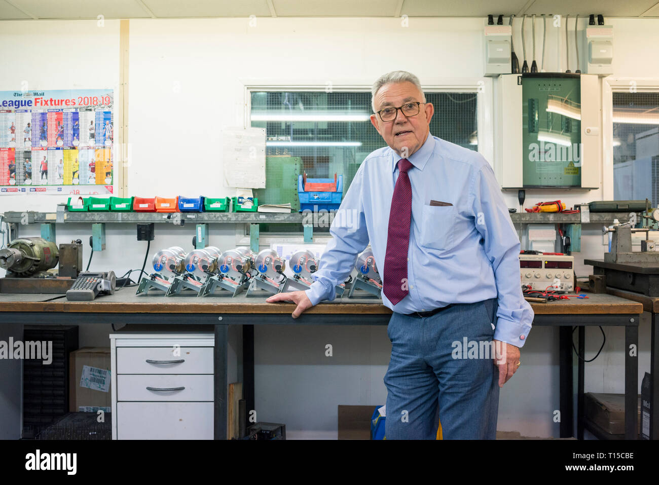 A friendly older gentleman / business owner standing in and on the ...