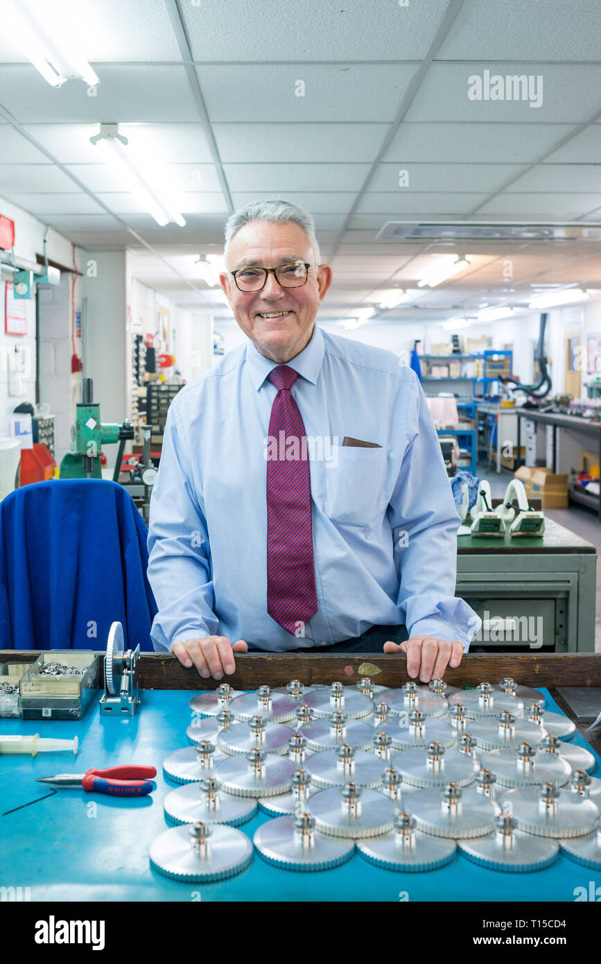 A friendly older gentleman / business owner standing in and on the ...