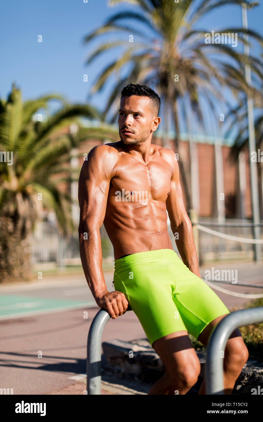 Barechested muscular man exercising outdoors looking around Stock Photo ...