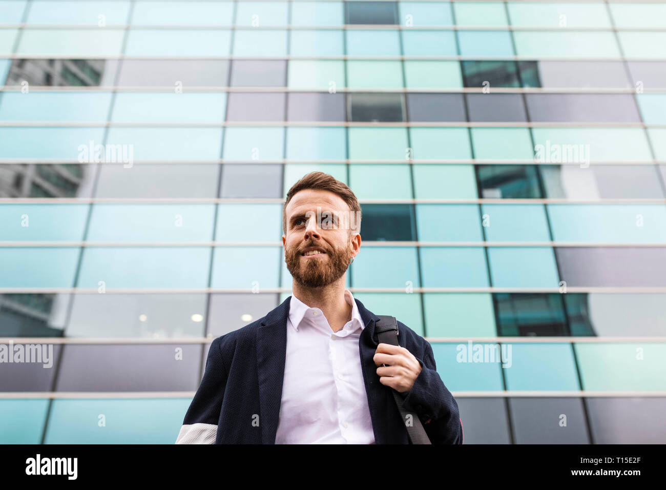 Stylish businessman in front of office building looking around Stock ...