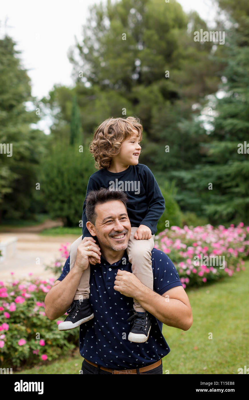 Happy father carrying son on shoulders in park Stock Photo - Alamy