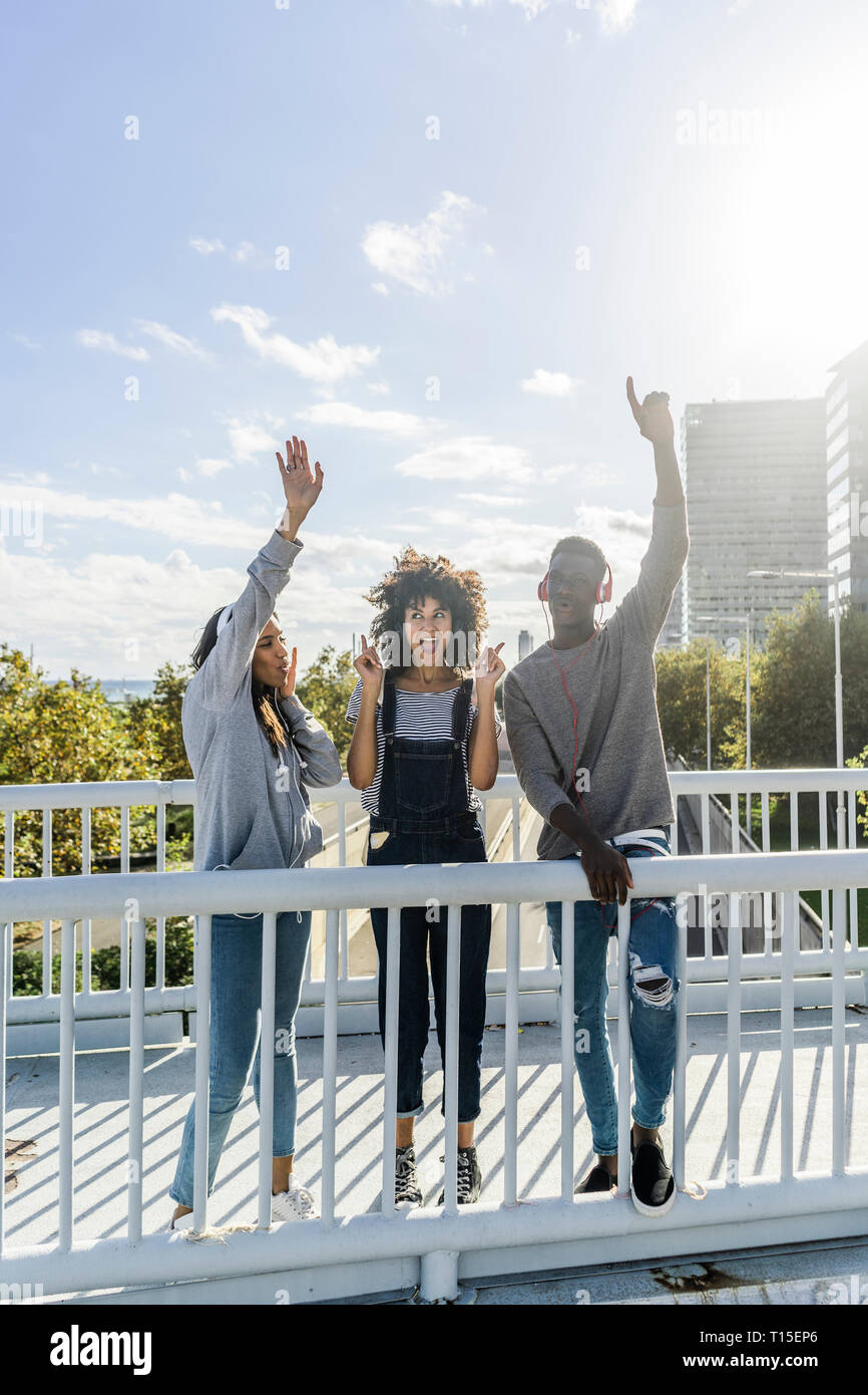 Friends standing on a bridge, having fun, listening music Stock Photo ...