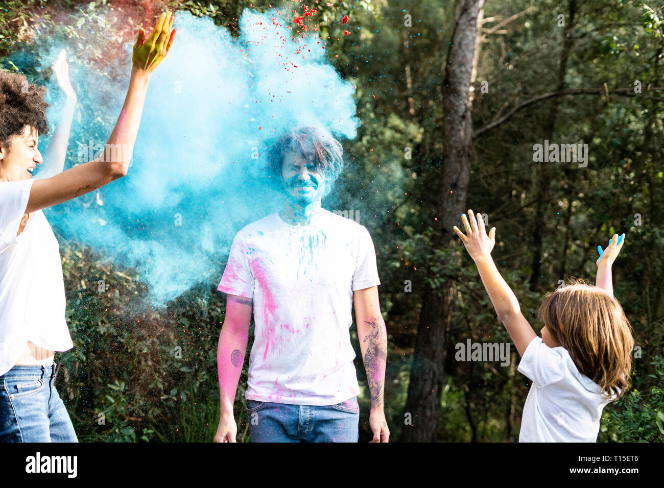 Family throwing colorful powder paint, celebrating Holi, Festival of ...
