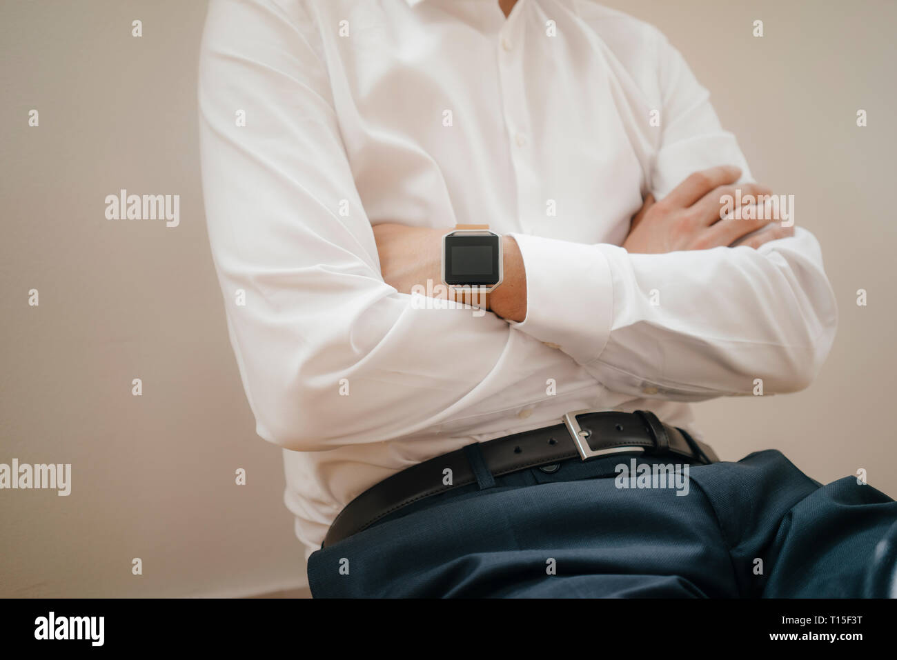Mid section of a businessman wearing smartwatch with arms crossed Stock ...