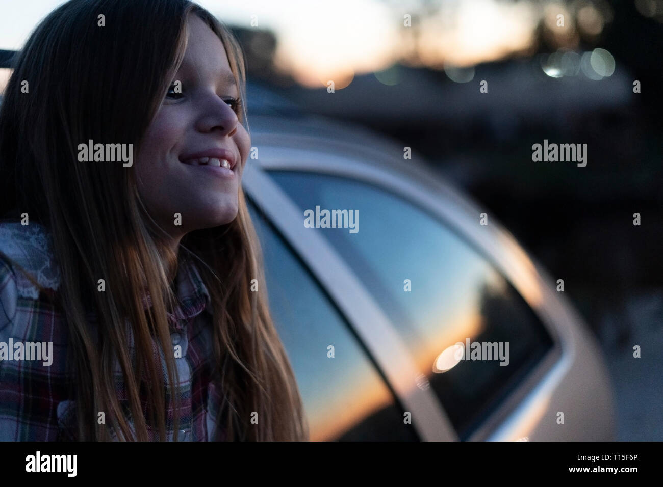 Content girl looking out of car window watching sunset Stock Photo - Alamy