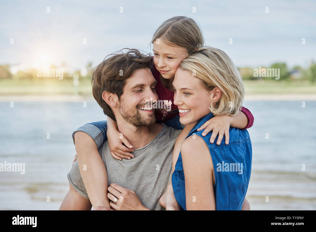 Germany, Duesseldorf, happy family with daughter at Rhine riverbank ...