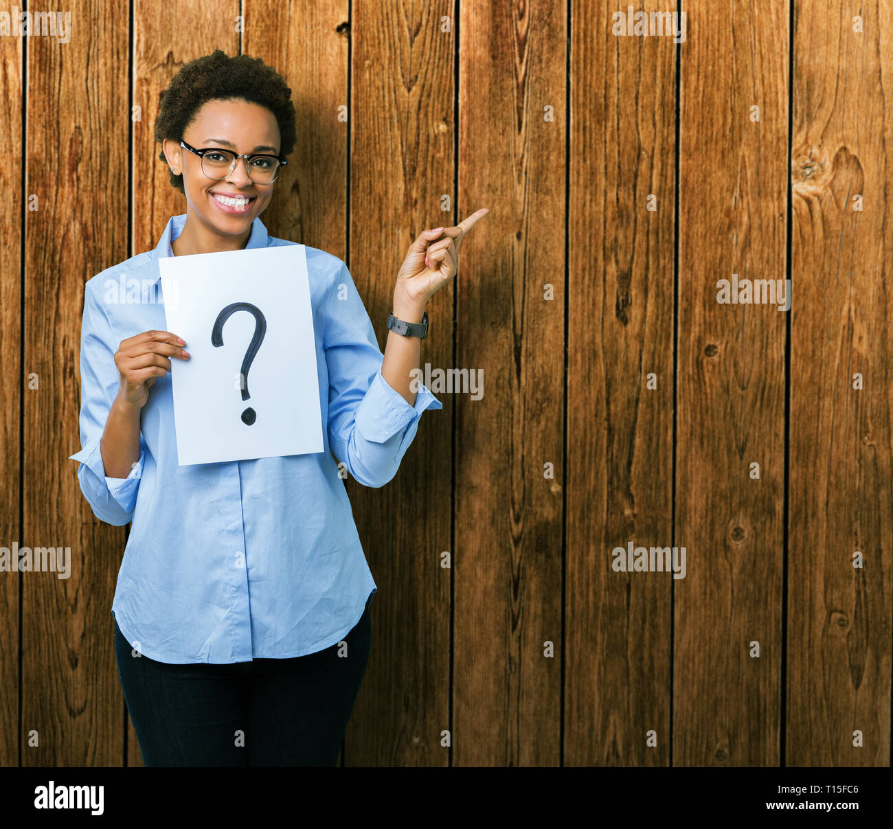 Young african american woman holding paper with question mark over ...