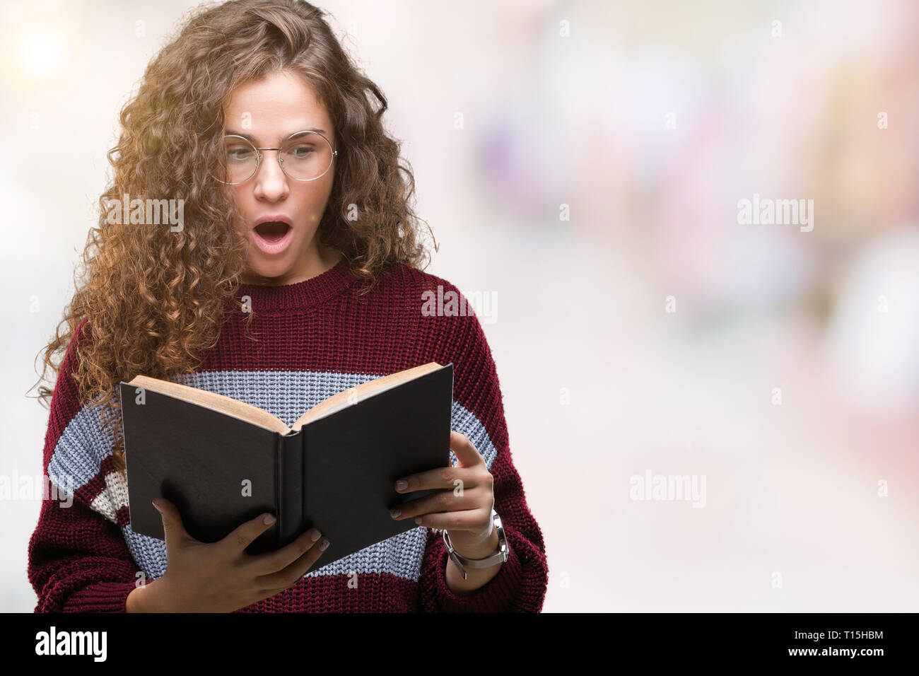 Young brunette girl reading a book wearing glasses over isolated ...