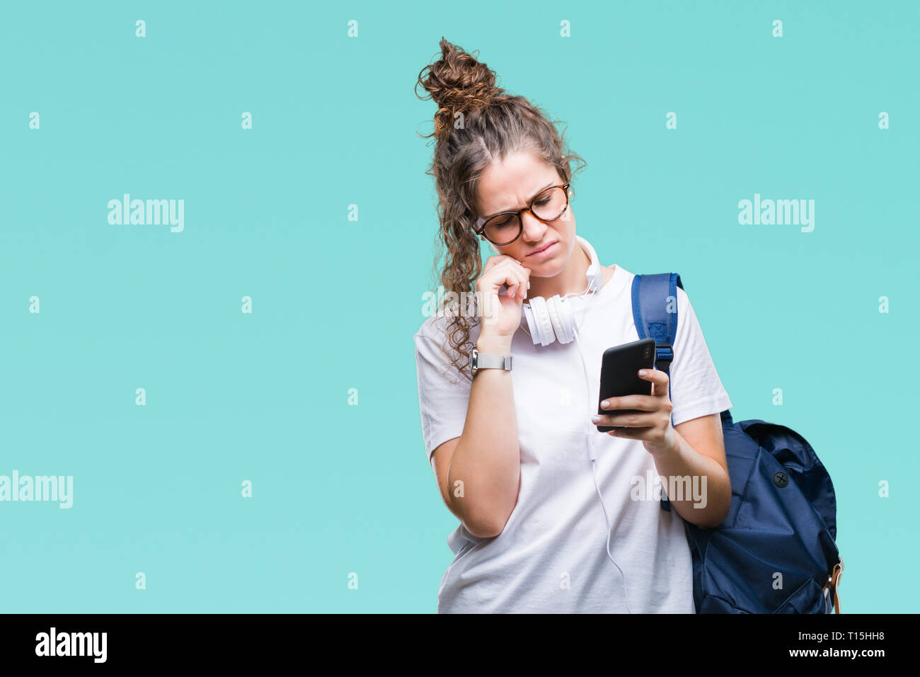 Young brunette student girl wearing backpack, headphones and smartphone ...