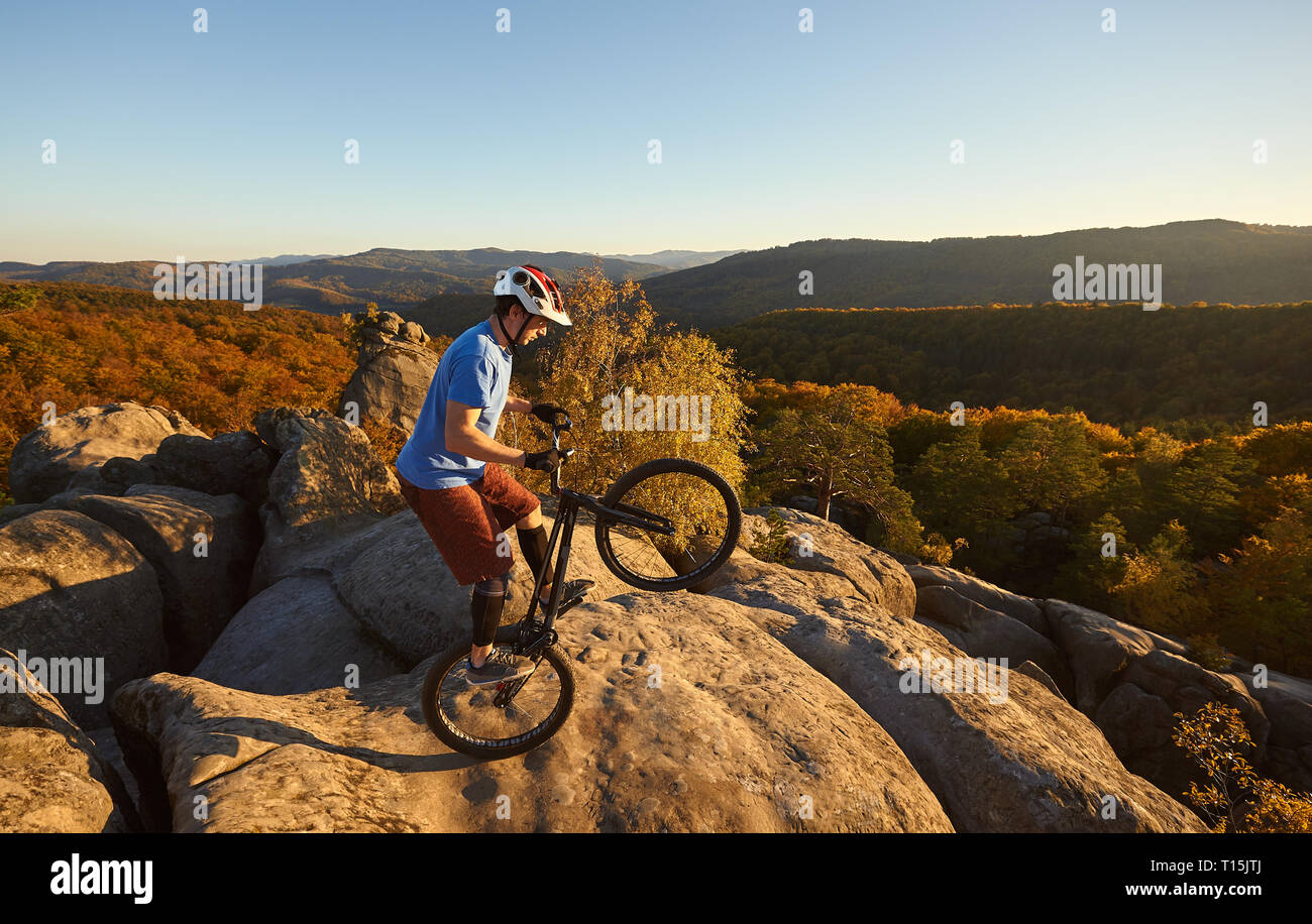Athlete cyclist riding on back wheel on trial bicycle. Sportsman biker ...