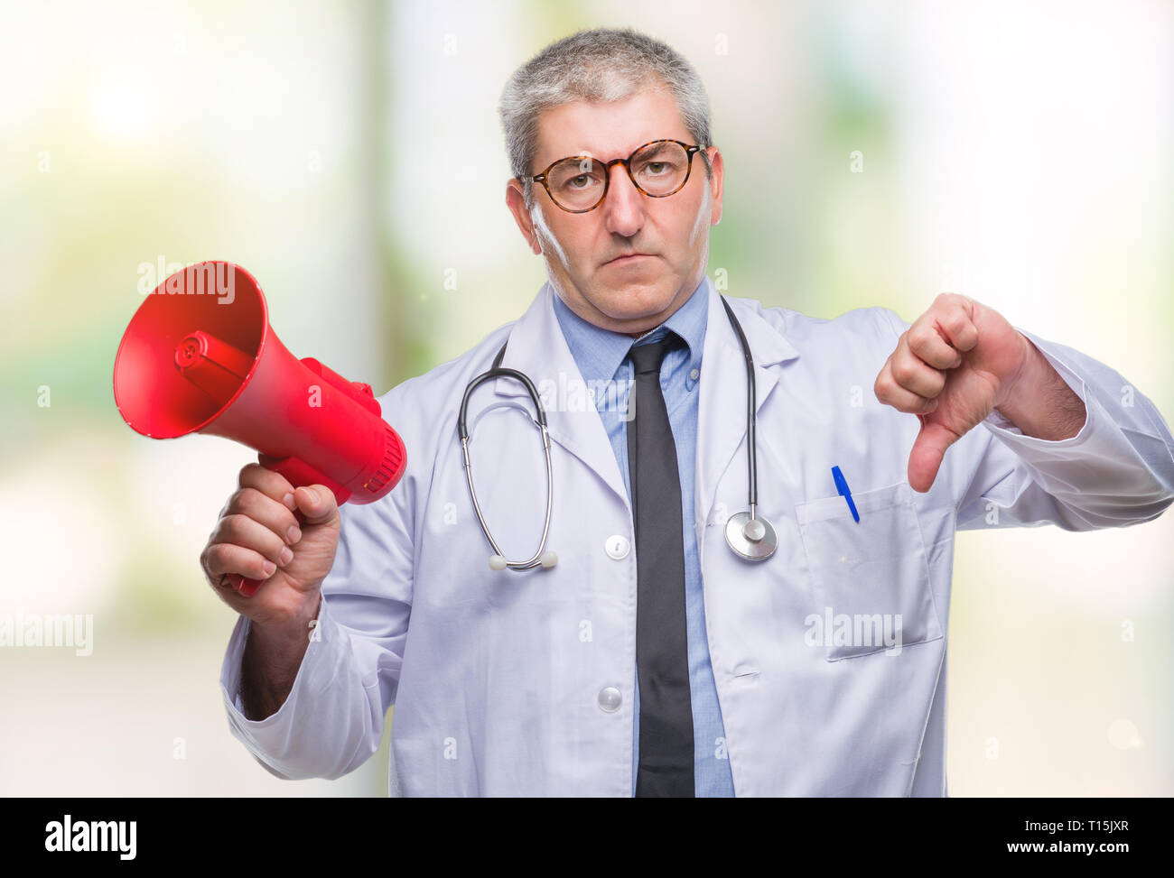 Handsome senior doctor man yelling through megaphone over isolated ...