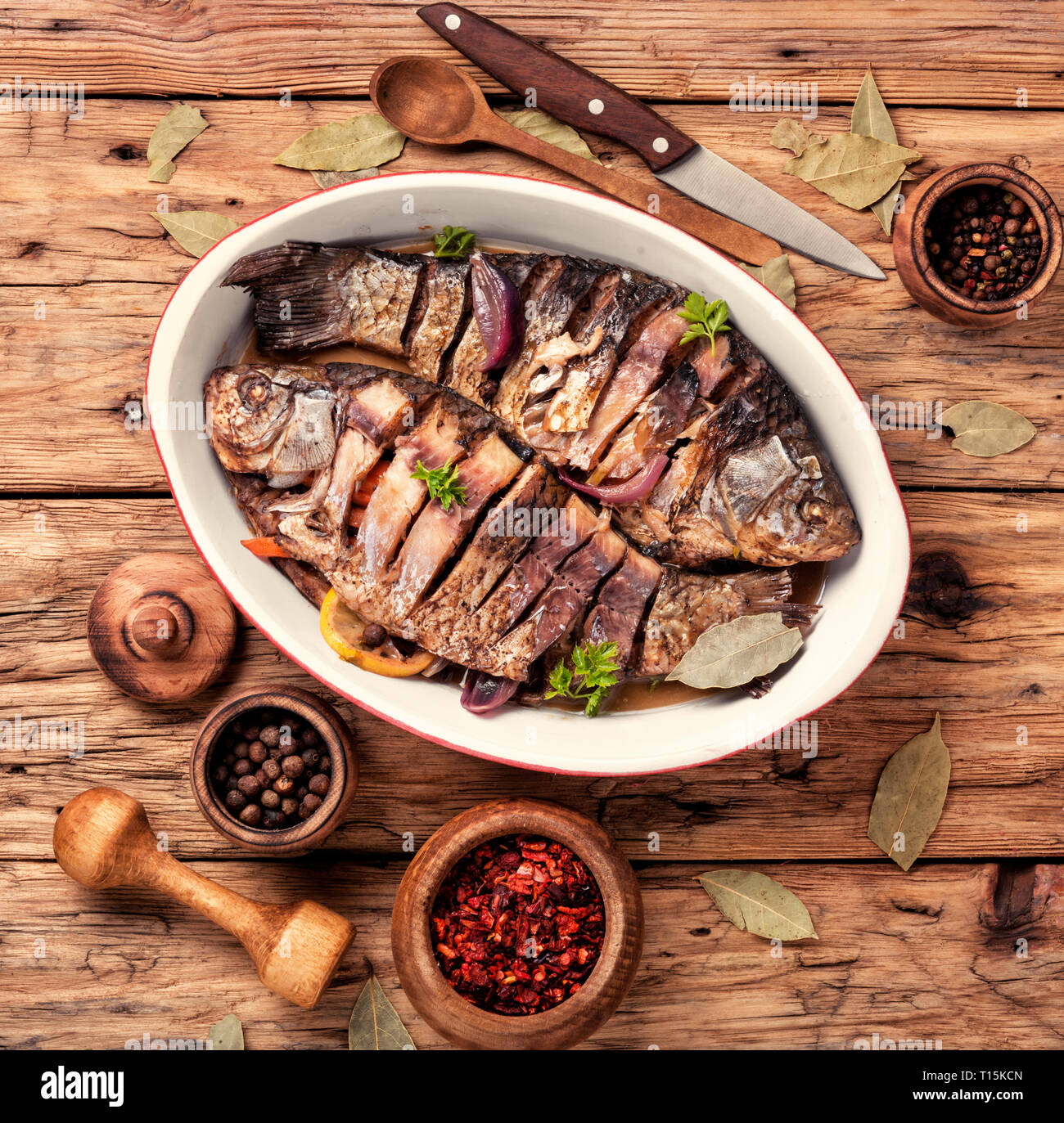 Grilled whole fish loaded with citrus, herbs and spices on rustic ...