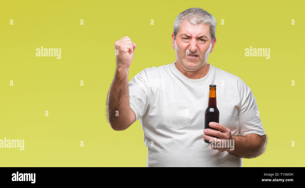 Handsome senior man drinking beer bottle over isolated background ...