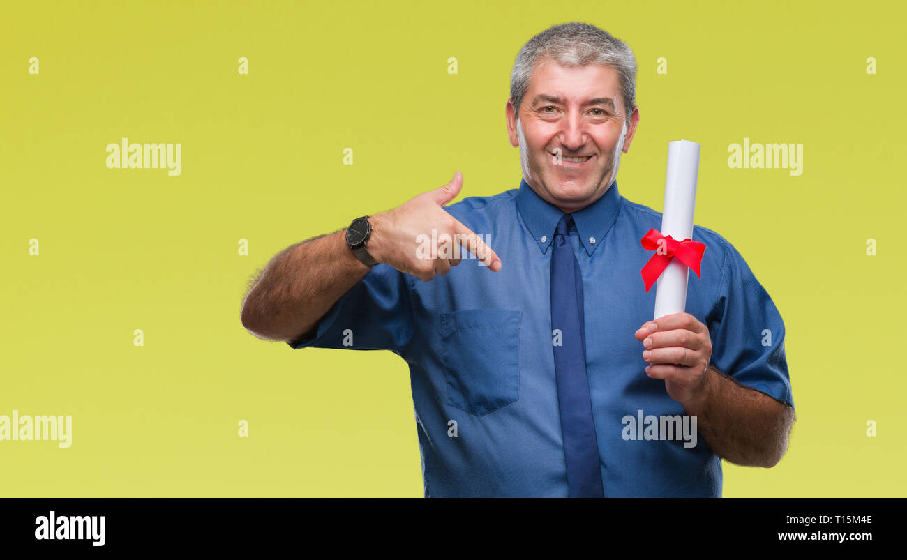 Handsome senior man holding degree over isolated background with ...