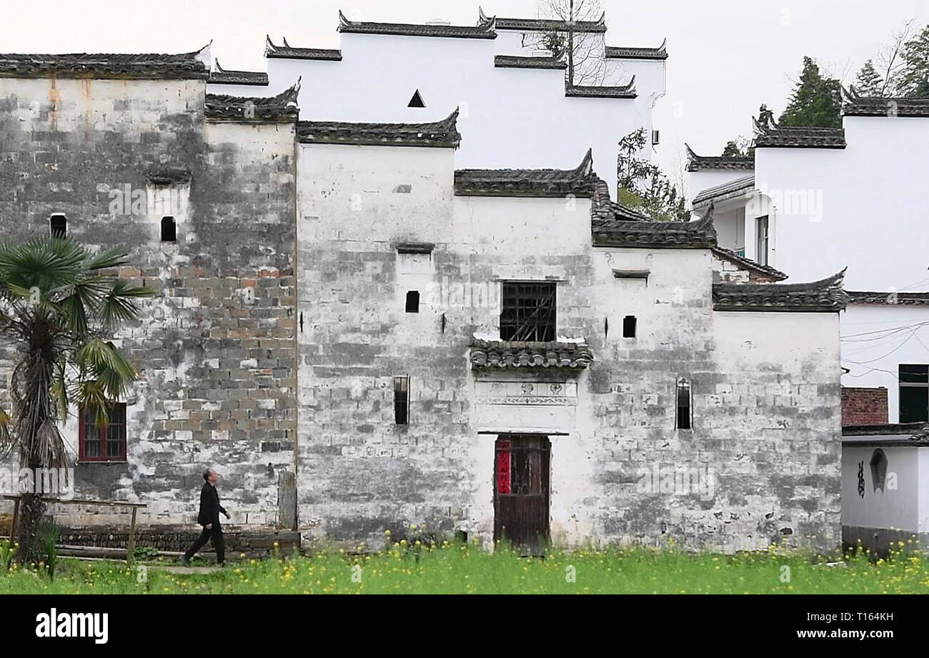 Jiangxi, China. 24th Mar, 2019. Yu Youhong walks past an ancient ...