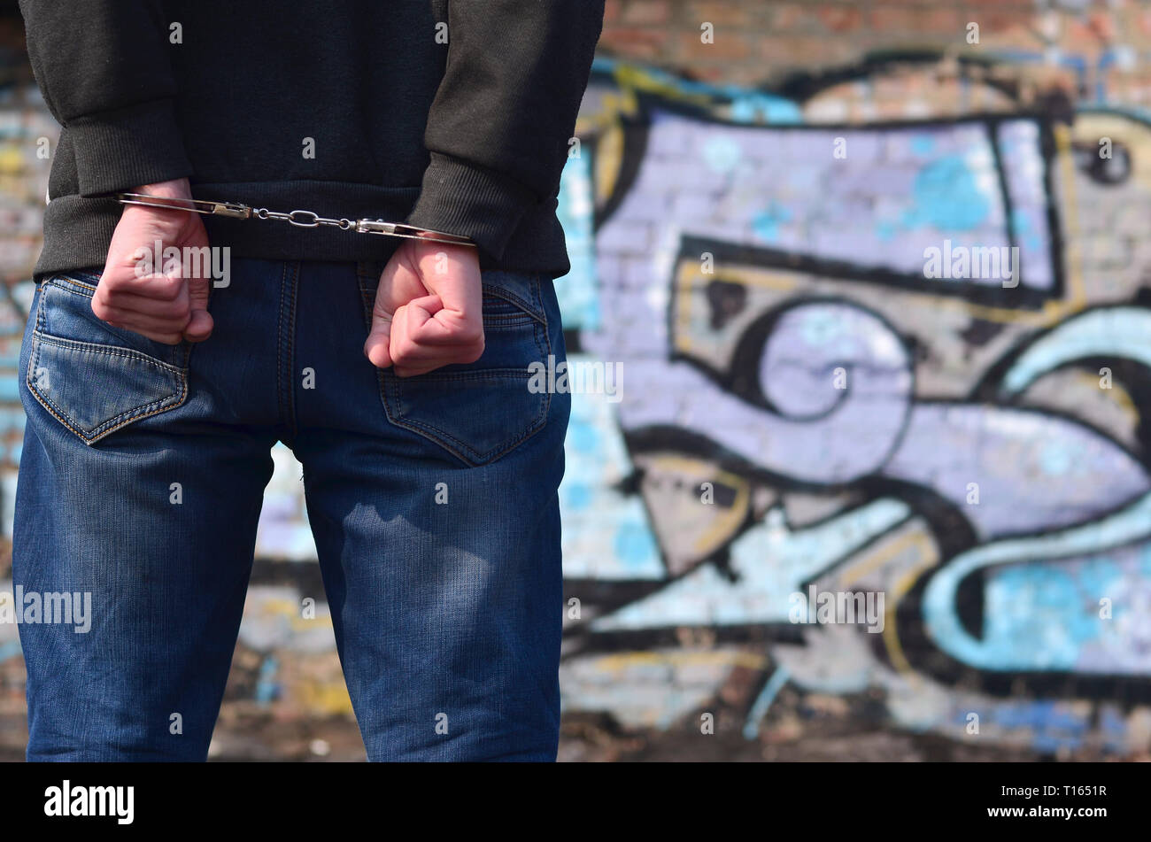 Back view of the arrested bandit from the ghetto against the background ...