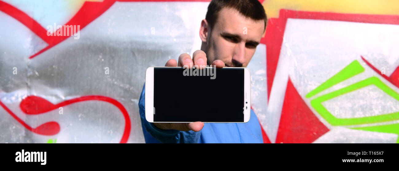 The graffiti artist demonstrates a smartphone with an empty black ...