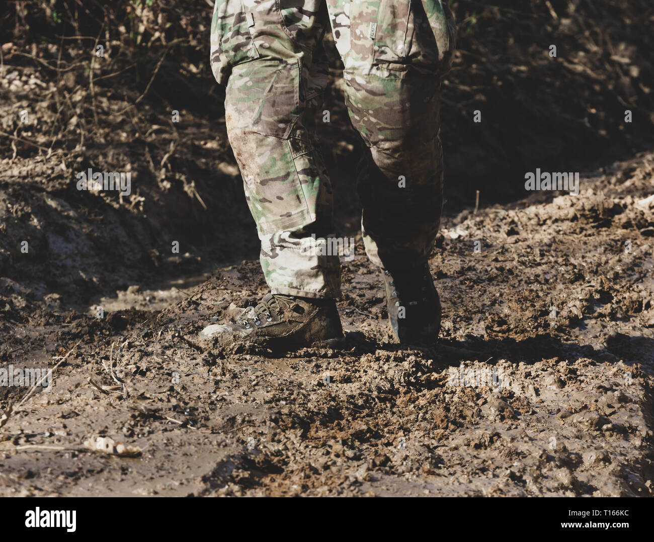 Brown military boots on mud and puddle Stock Photo - Alamy