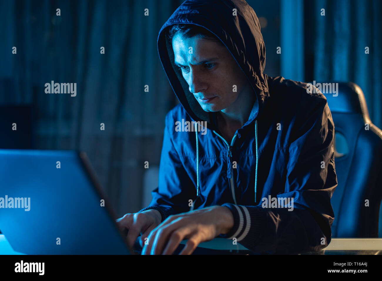 Cybercriminal Hacker In The Hood Typing Program Code While Stealing Access Databases With