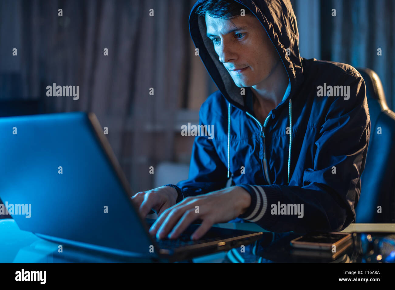 Cybercriminal Hacker In The Hood Typing Program Code While Stealing Access Databases With