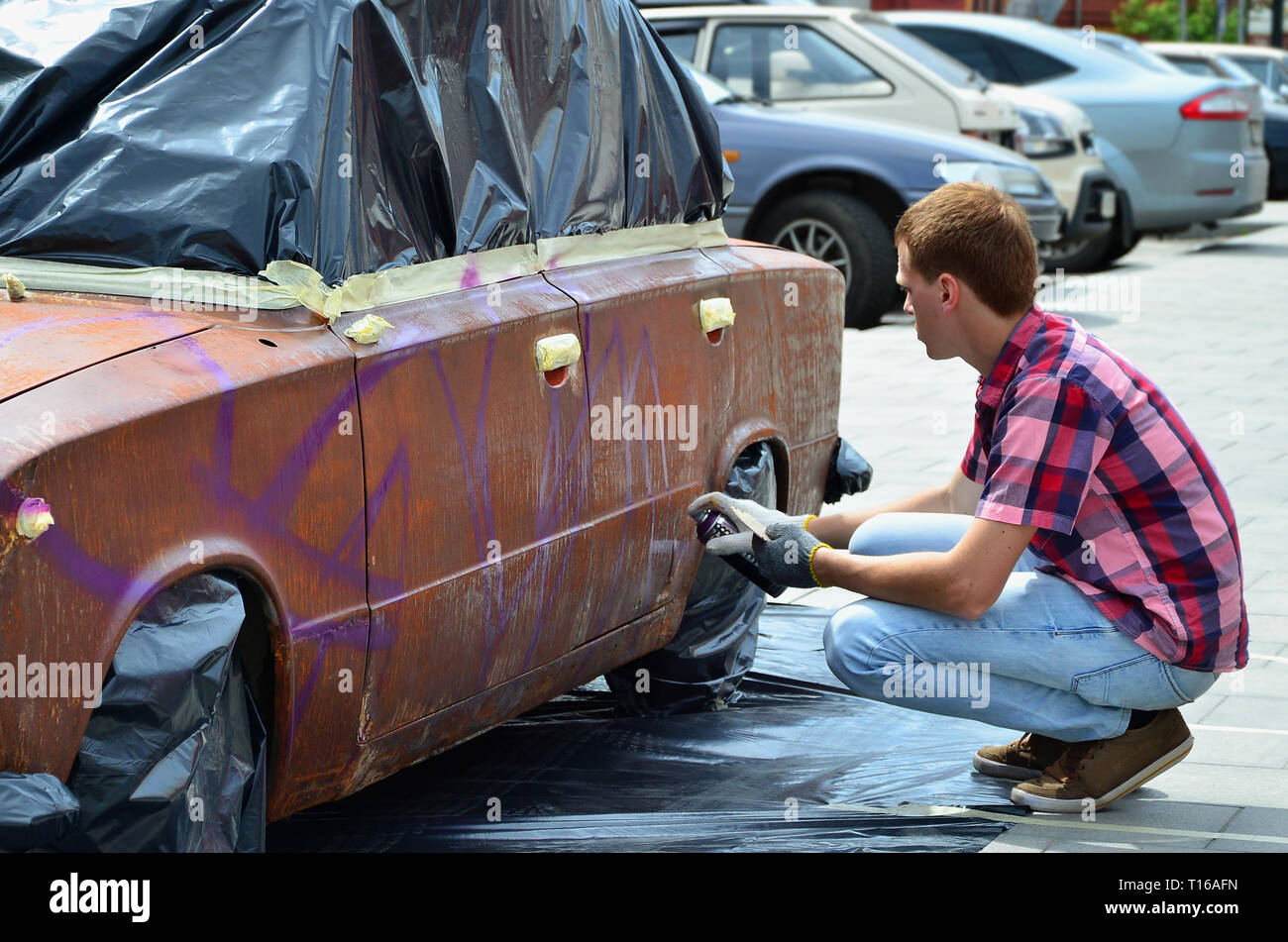 A young red-haired graffiti artist paints a new colorful graffiti on ...