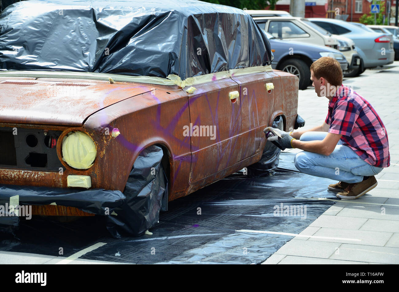 A young red-haired graffiti artist paints a new colorful graffiti on ...