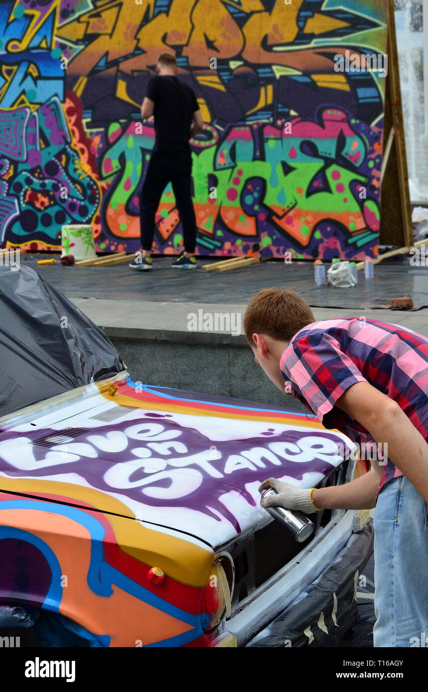 A young red-haired graffiti artist paints a new colorful graffiti on ...