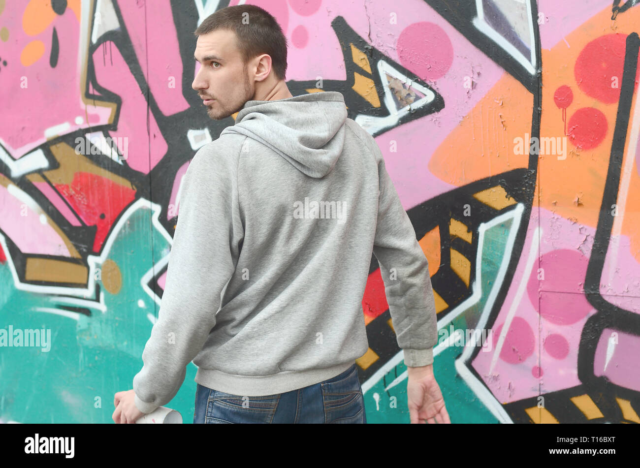 A young graffiti artist looks around while drawing. Vandal tries to be ...