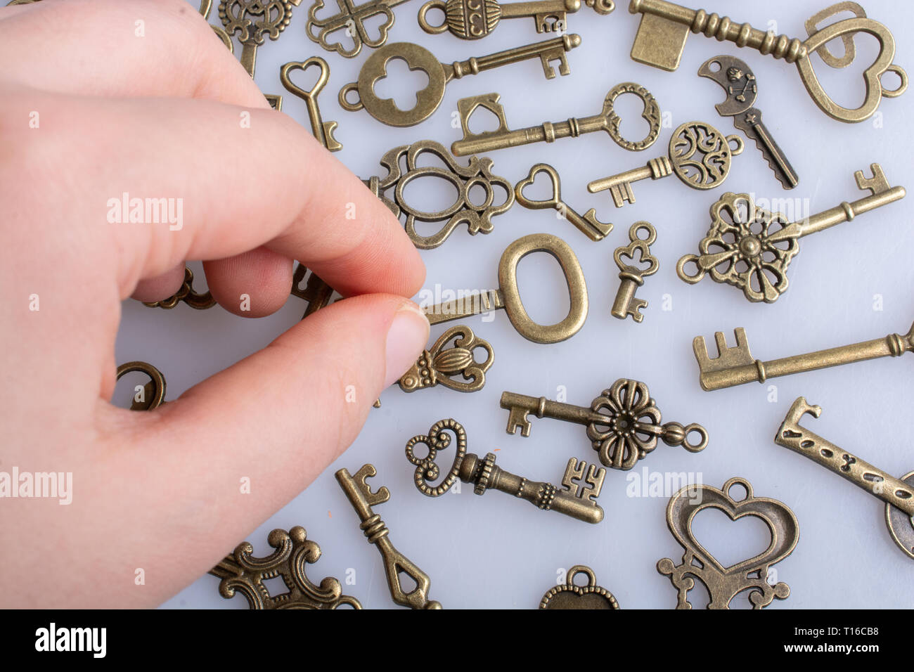 Hand and retro style metal keys on a white background Stock Photo - Alamy
