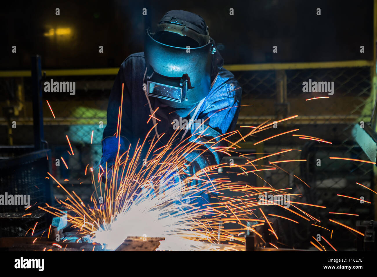 Industrial worker is welding repair steel part Stock Photo - Alamy