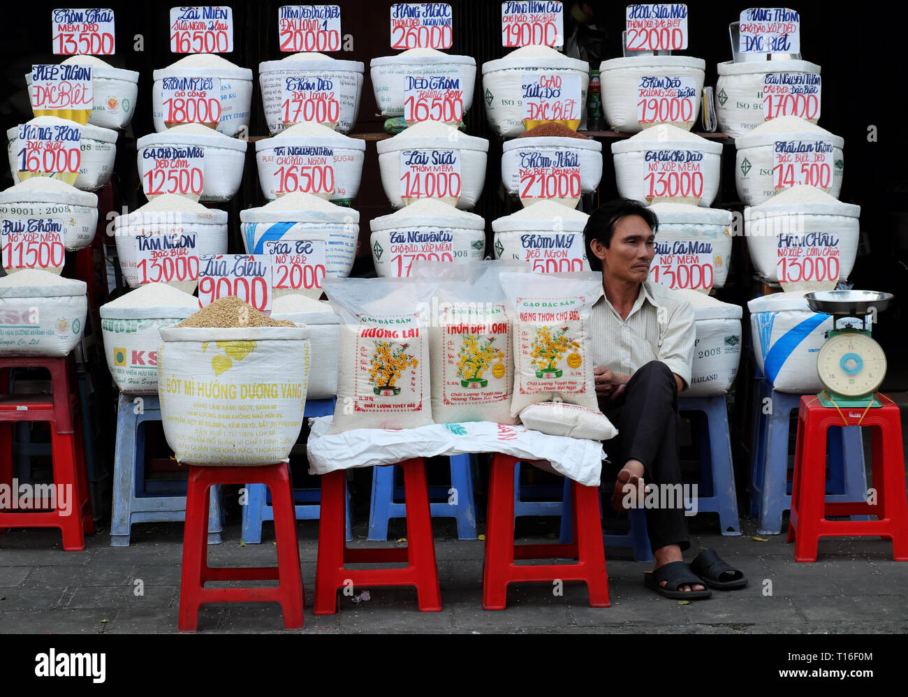 Vietnamese salesman sit at rice store of outdoor farmer market, many ...