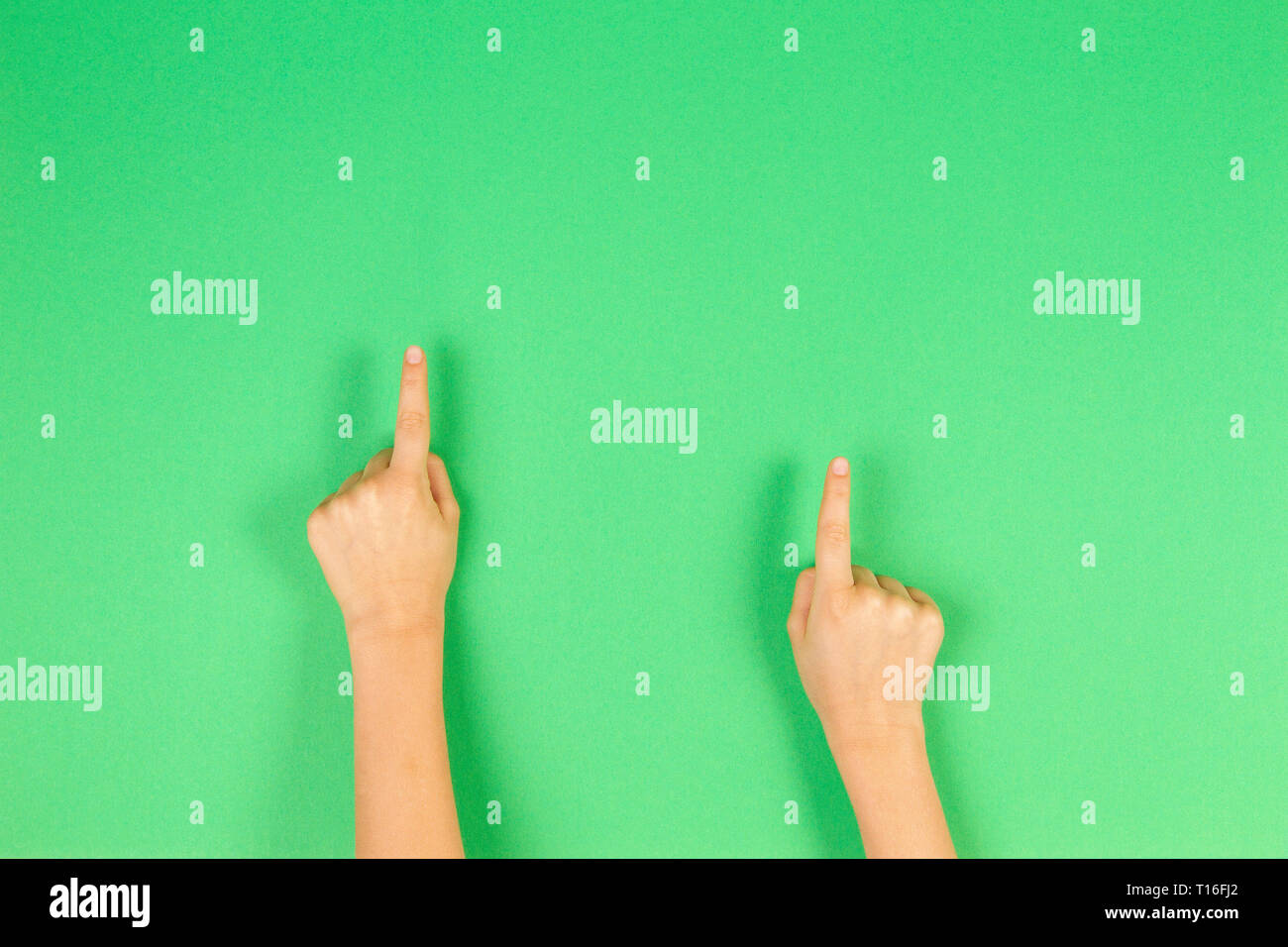 Child hands fingers pointing on light green background Stock Photo - Alamy