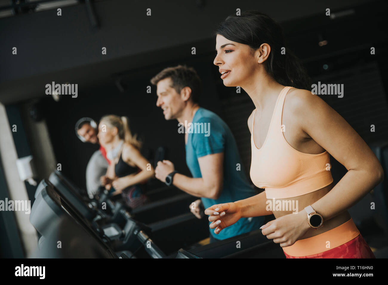 Group of young people running on treadmills in modern gym Stock Photo ...