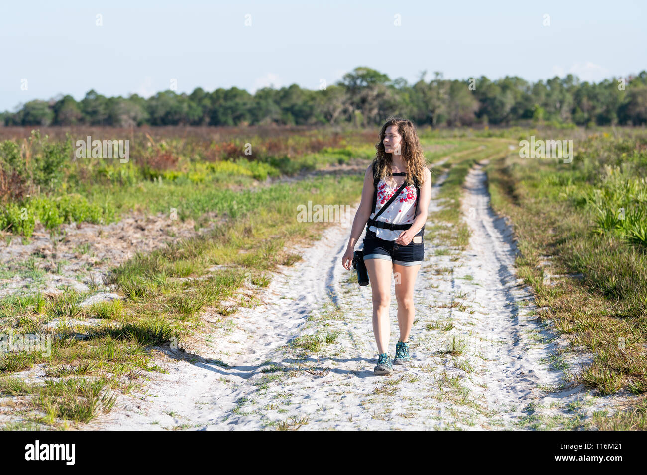 Woman travel photographer walking on prairie landscape with and trail ...