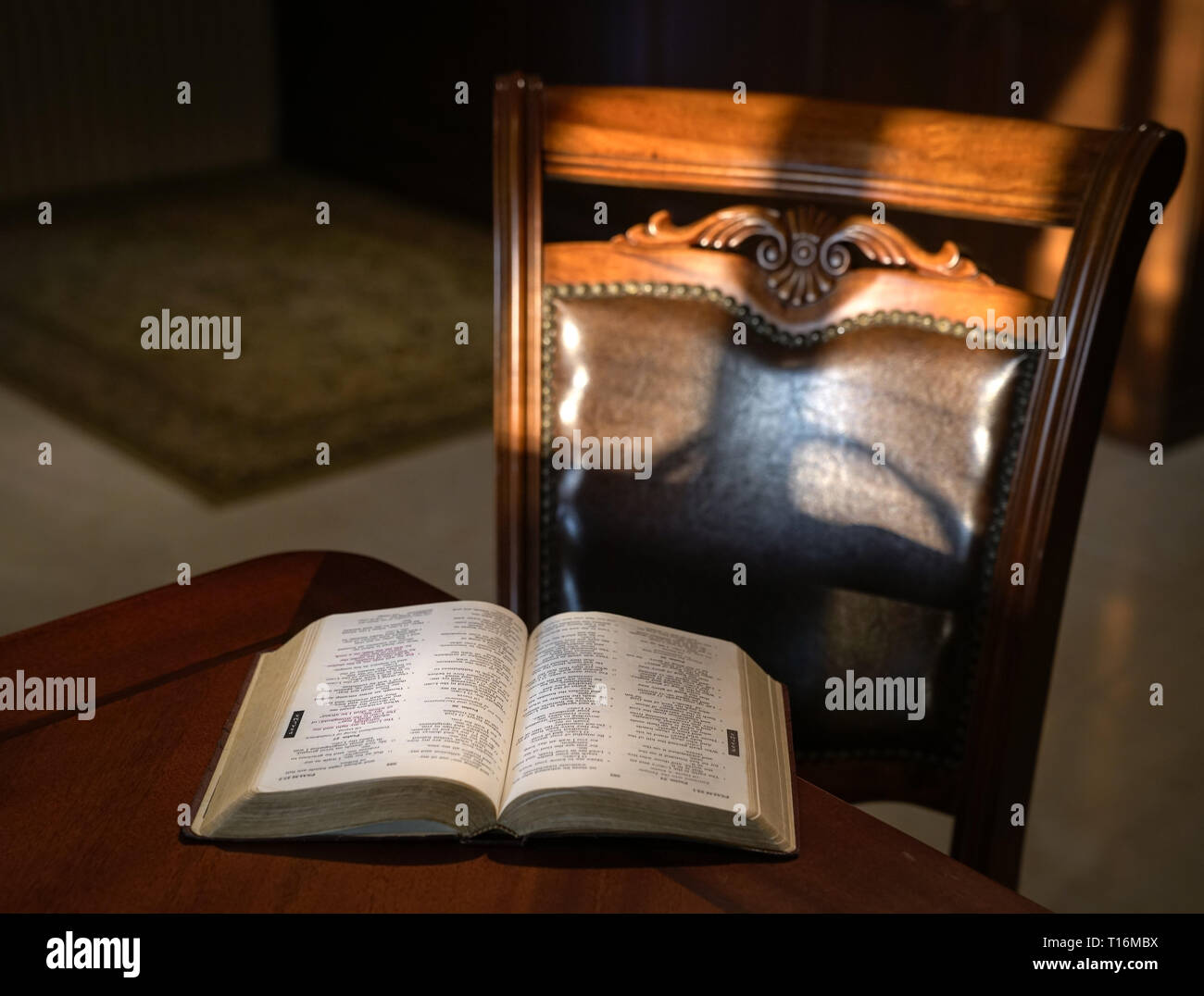 Open bible on a dark wood table and chair at the background Stock Photo ...