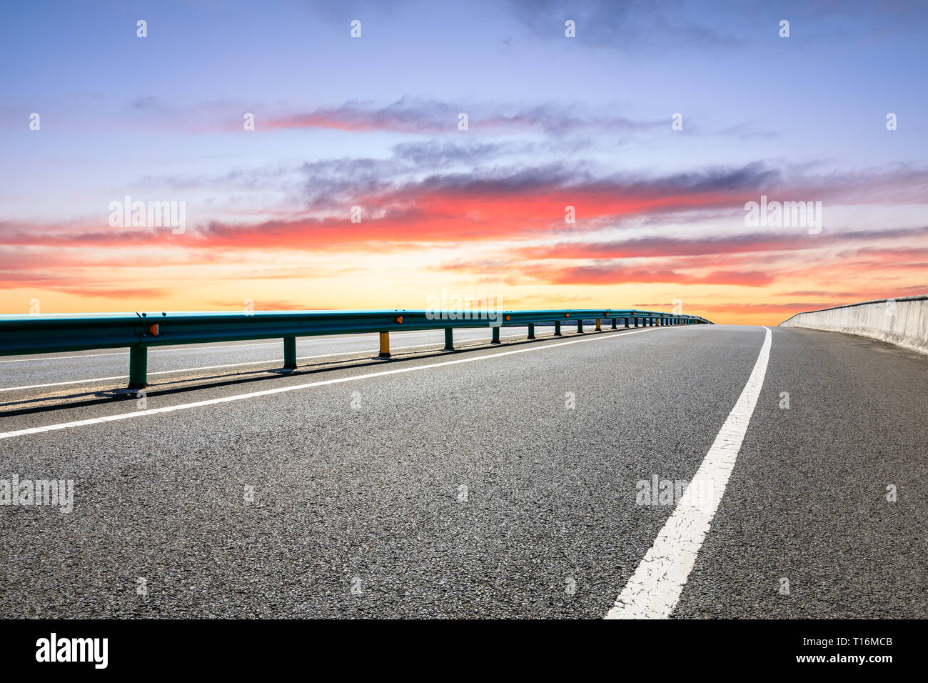 Asphalt highway ground and beautiful clouds at sunrise Stock Photo - Alamy