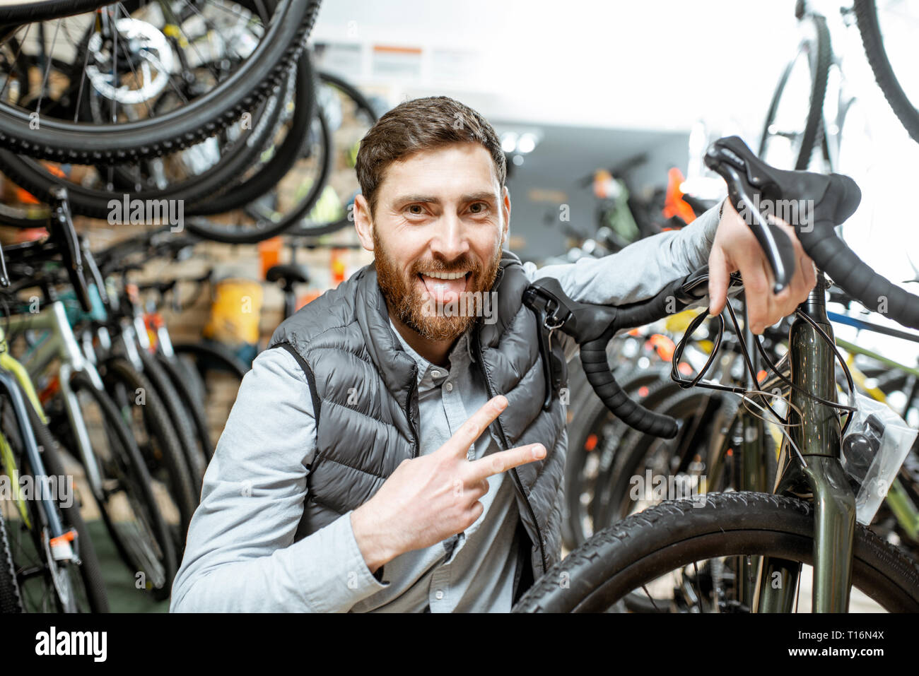 Portrait of a handsome man as a buyer or salesperson with bicycle at ...