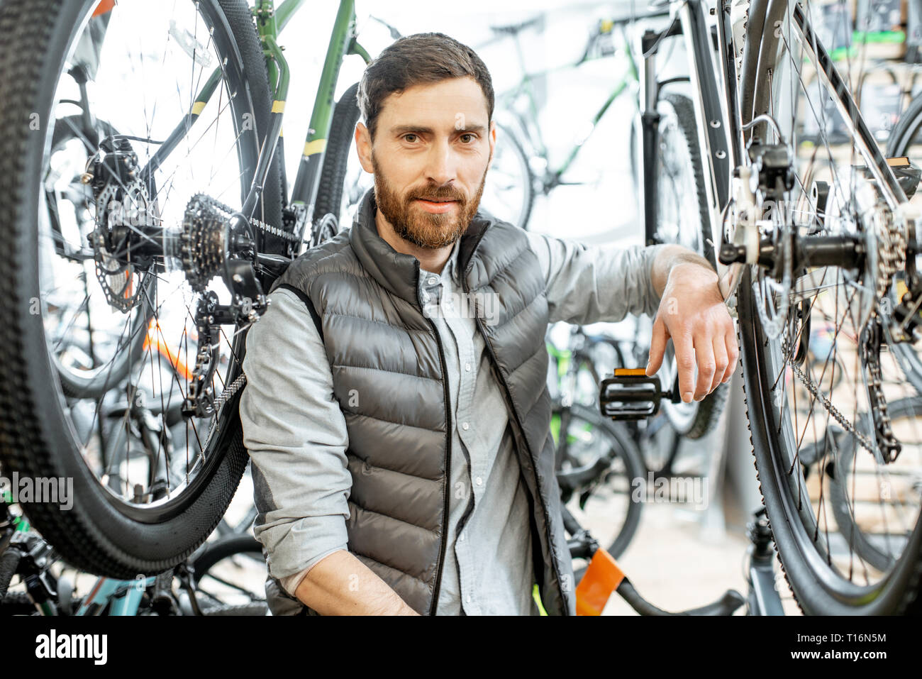 Portrait of a handsome man as a buyer or salesperson at the bicycle ...
